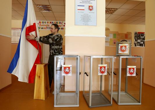 Election commission official installs Crimean flag during preparations ...
